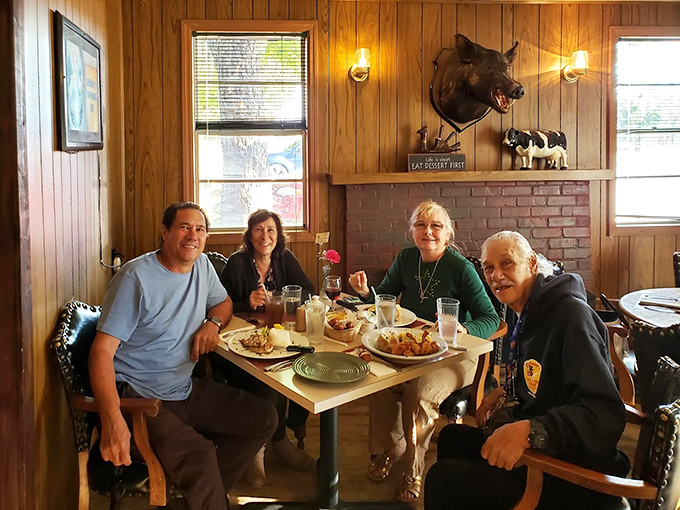 Happy diners gathered around a table, proving that good food has always been the world's most effective social network.