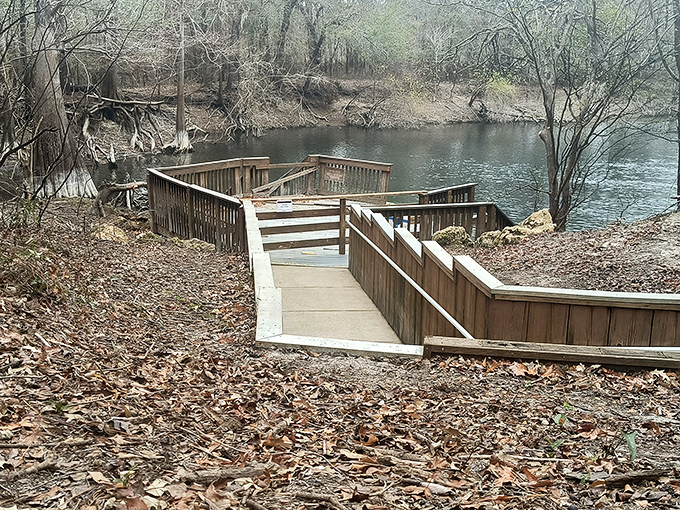 Autumn's fallen leaves frame the boardwalk like nature's red carpet, inviting you to the main attraction&mdash;that impossibly clear water ahead. 