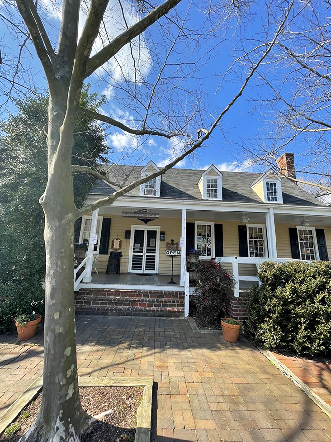 The yellow clapboard exterior under blue Virginia skies promises authentic experiences inside&mdash;no colonial costumes required, just real Southern cooking.