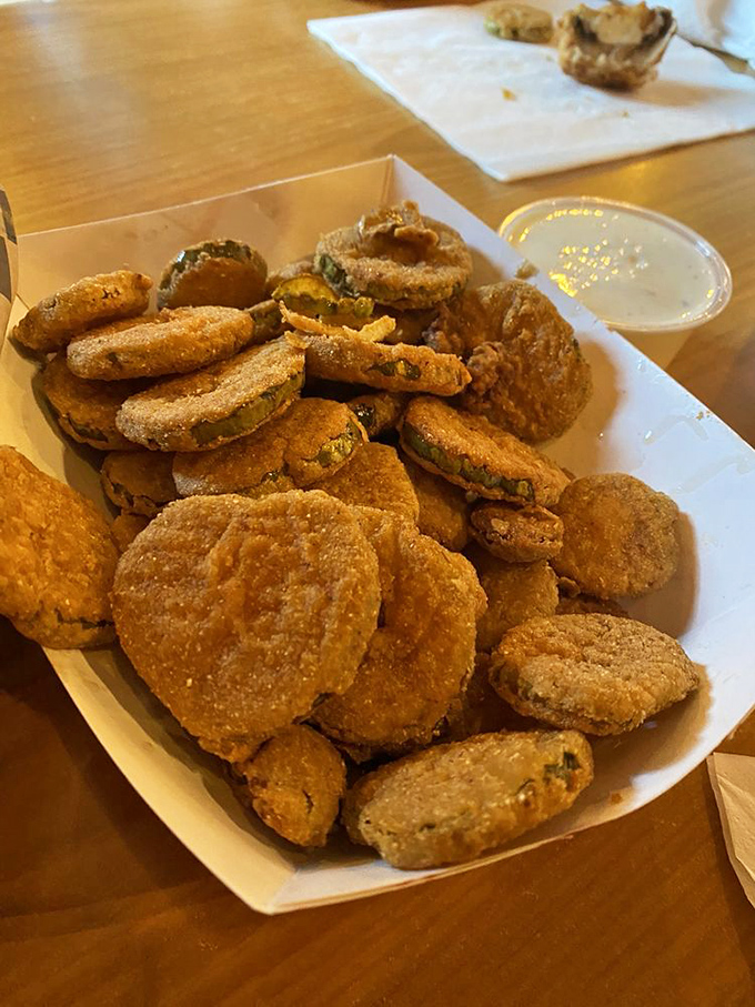 Fried pickles: the perfect marriage of tangy and crispy. These golden discs deliver a vinegary punch beneath their crunchy cornmeal armor.