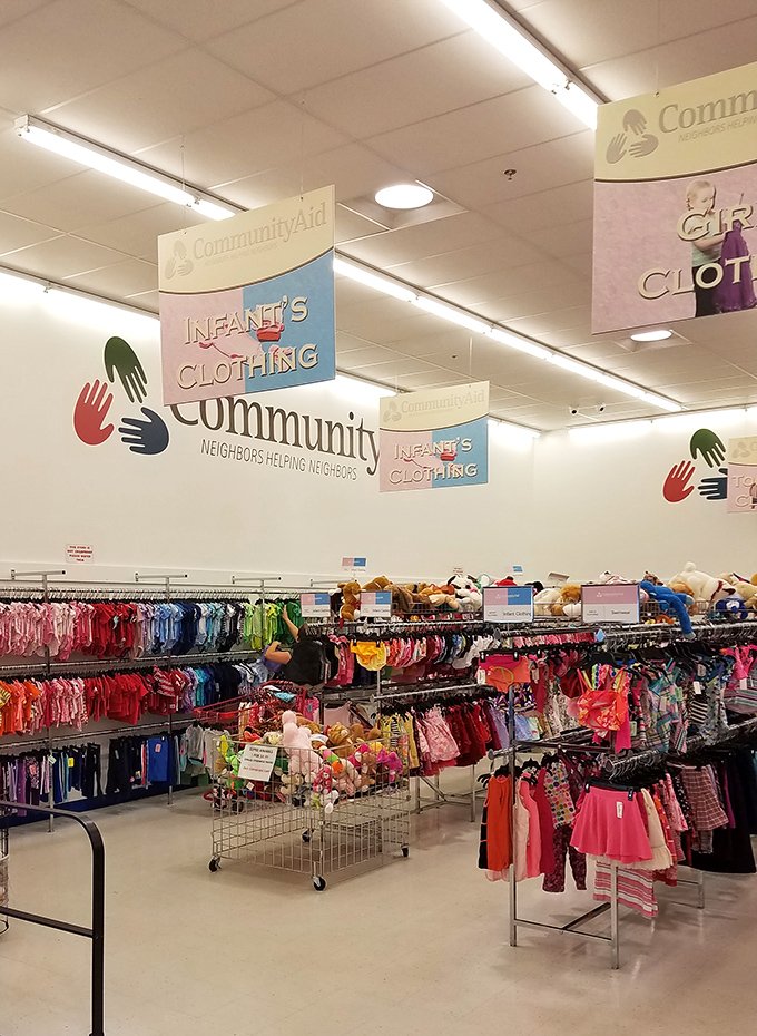 The infant clothing section explodes with color under cheerful signage. Tiny outfits that were barely worn await their next brief moment in the spotlight.