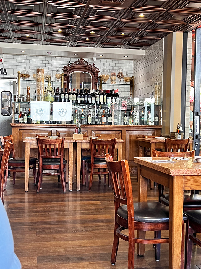 Wooden chairs, marble tables, and a bar that looks like it was transported directly from Rome. Even the ceiling tiles are having a good time.