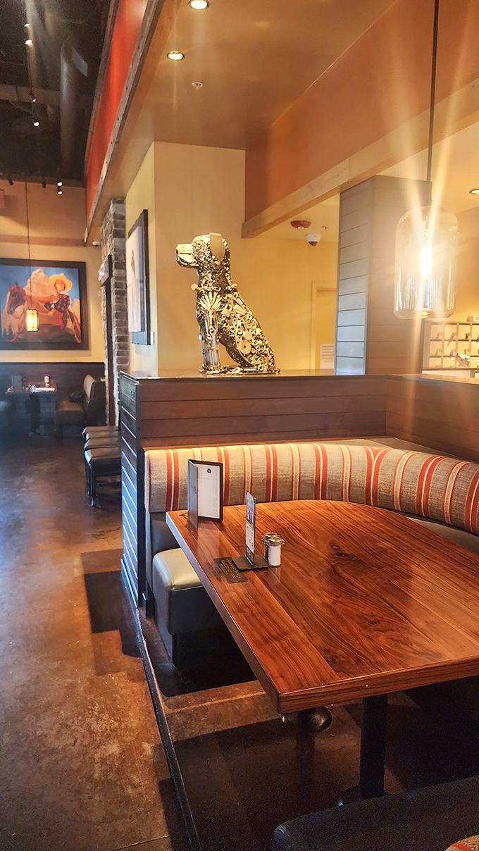 The metallic dog sculpture stands guard over cozy booths. This clever design touch reminds you that man's best friend inspired this culinary playground.