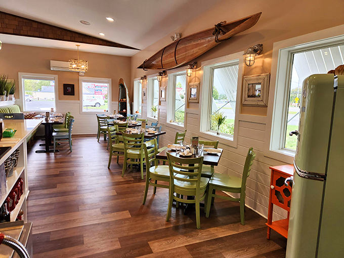 Nautical without being kitschy&mdash;the dining room's green chairs and wooden canoe overhead strike that perfect coastal-casual balance.