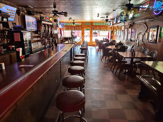 The bar area stretches into the distance like a runway of possibilities, with stools that have supported generations of local stories and celebrations.