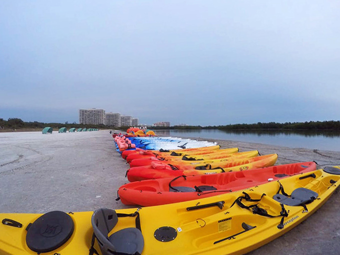 Kayak rainbow waiting for adventurers. Each vessel promises a different story to tell over dinner tonight.