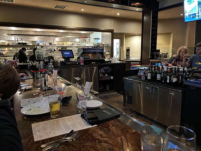 A glimpse into the kitchen reveals the orchestrated chaos where culinary magic happens&mdash;stainless steel, focused chefs, and sizzling anticipation.