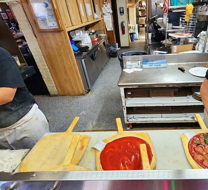 Pizza artistry happens here, where sauce-laden wooden paddles transform simple ingredients into neighborhood legends.