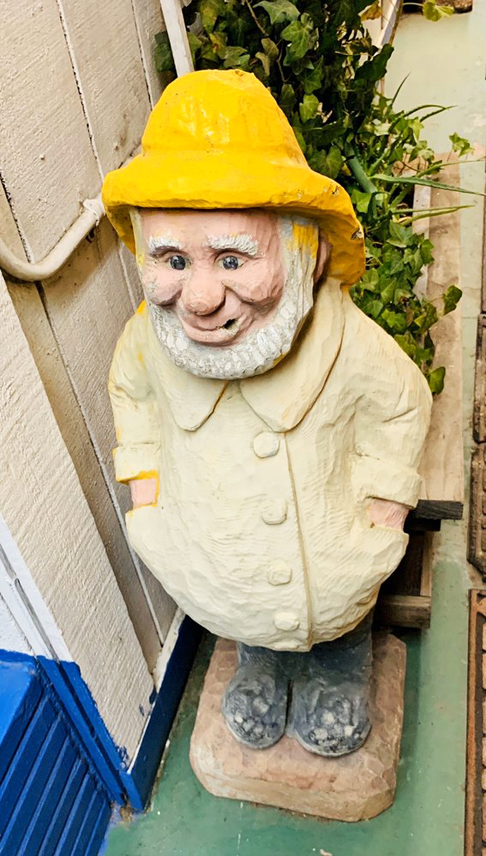 The whimsical fisherman statue stands guard outside, a silent sentinel promising good things to those who venture inside.