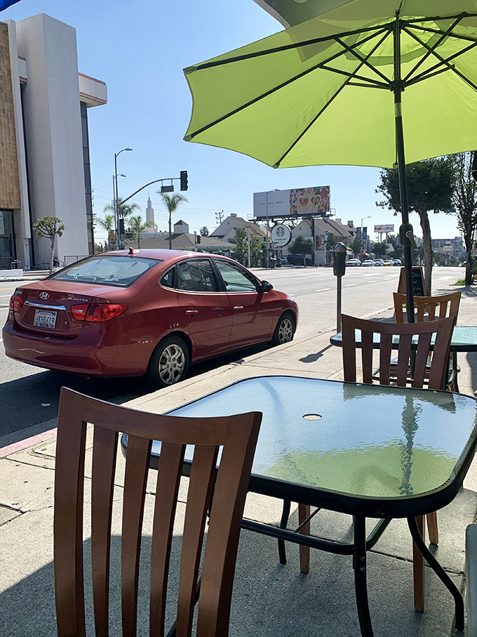 Sidewalk seating where you can people-watch while your breakfast cools, all under the protection of a cheerful green umbrella. Pure LA bliss.