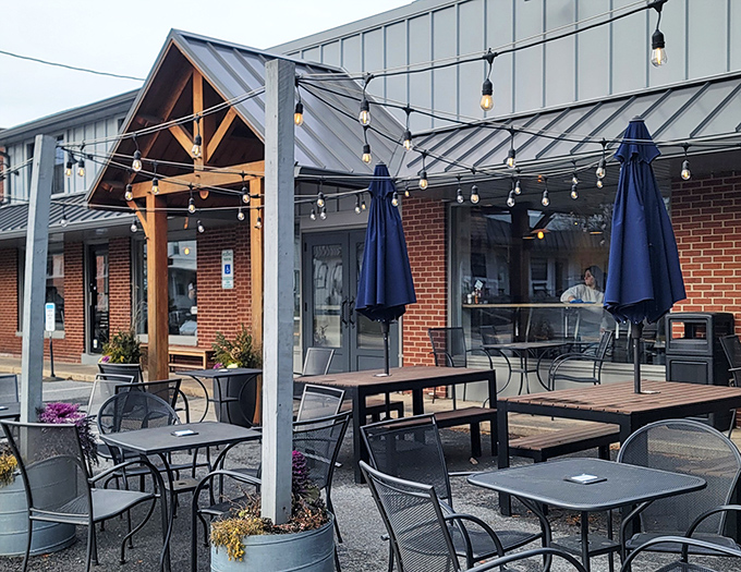 The outdoor seating area, where string lights create breakfast ambiance even at noon, and metal tables await your coffee-fueled conversations.