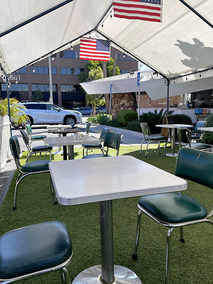 Outdoor dining with Americana flair&mdash;where artificial turf meets metal tables under American flags. It's patriotism you can eat with.