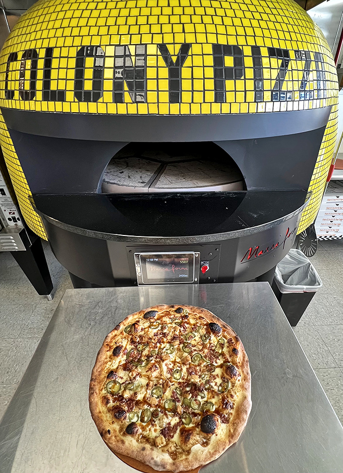 "Colony Pizza" spelled out in yellow tiles isn't just decoration—it's a beacon of hope above a pizza oven that means business.