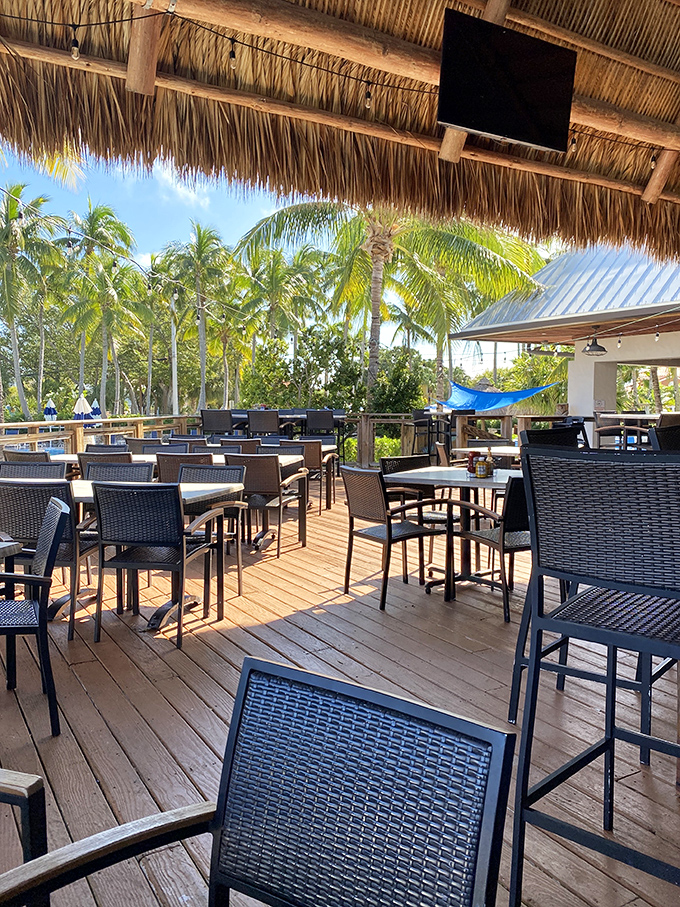 Paradise found: palm trees sway above the outdoor deck where tables await hungry travelers seeking that perfect blend of sunshine and seafood.