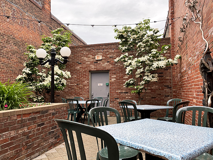 The brick-walled patio offers a secret garden escape in downtown Erie, where flowering trees soften the urban landscape.