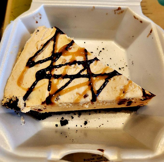 This slice of peanut butter pie isn't just dessert &ndash; it's therapy with a crust, drizzled with chocolate and caramel in a to-go container of happiness.