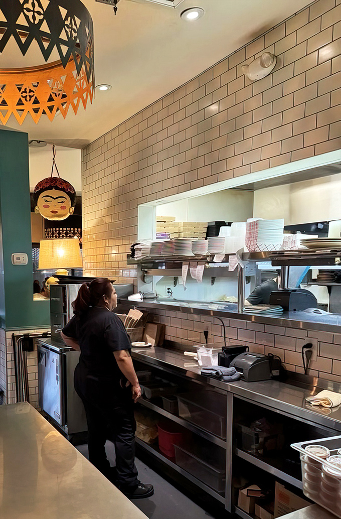 Behind the scenes, the open kitchen hums with activity, where culinary magic transforms simple ingredients into neighborhood legends.