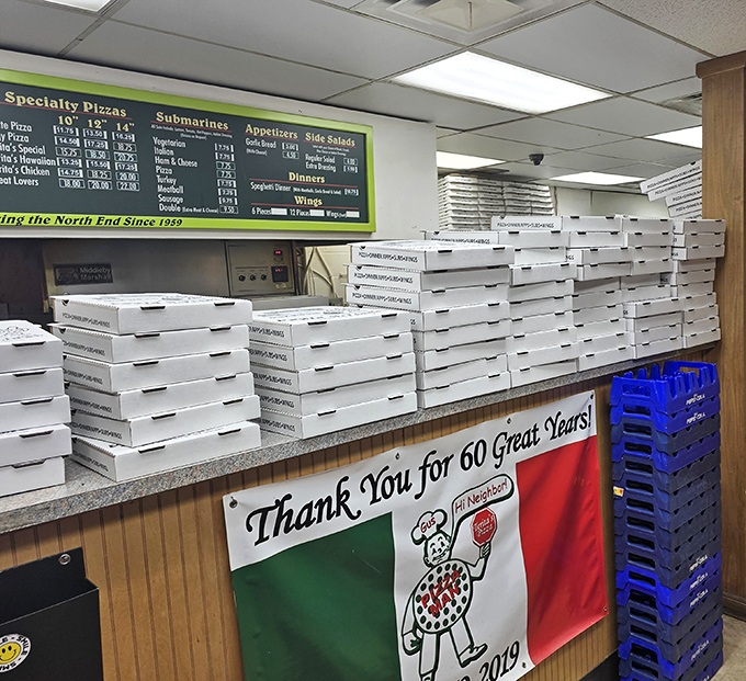 Stacks of pizza boxes await their precious cargo. Each white cardboard vessel soon to become someone's highlight of the day.