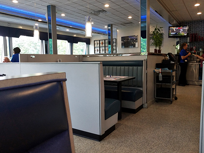 Blue vinyl booths standing at attention like soldiers guarding the sacred diner experience &ndash; private dining kingdoms where breakfast can be enjoyed at any hour.