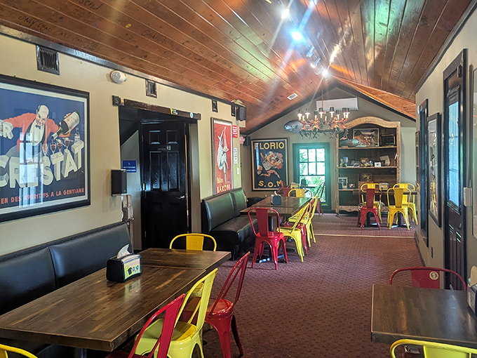 Colorful metal chairs pop against wooden tables in this dining area. The vintage posters and warm lighting create an atmosphere where you'll want to linger long after the meal.
