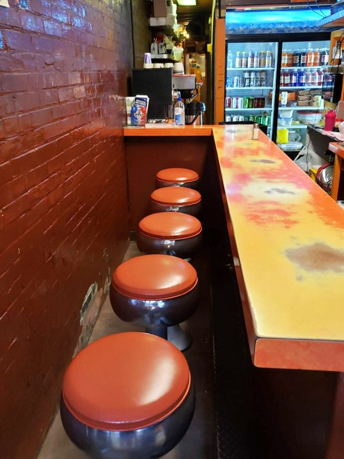 The counter seating—where strangers become friends united by the universal language of exceptional hot dogs. These stools have heard a million satisfied sighs.