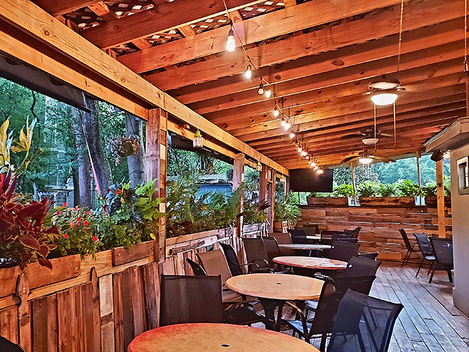 Evening magic happens when string lights illuminate wooden beams. This isn't just outdoor seating&mdash;it's dinner theater with trees as the backdrop.
