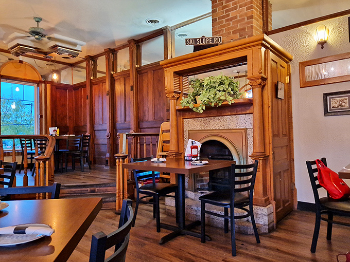 Cozy corner seating with rich wood paneling and a fireplace nearby—the restaurant equivalent of finding the perfect reading nook in your dream library.