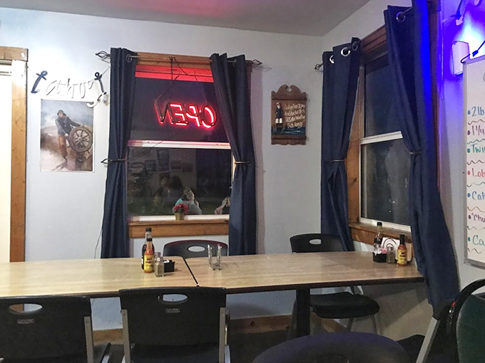 Evening light filters through navy curtains, transforming this simple dining space into a cozy retreat for seafood enthusiasts and hungry travelers alike.