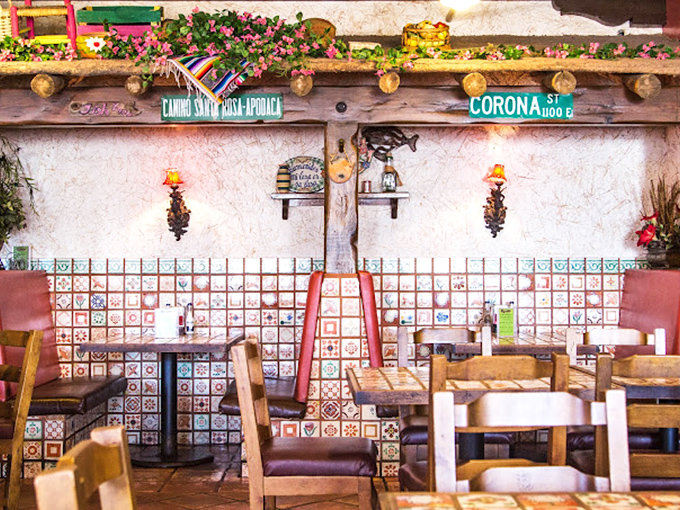 Decorative tiles climb halfway up the walls, while street signs and warm lighting create a dining space that feels both festive and intimate.