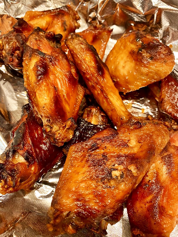 Smoked wings glistening with sauce that probably requires signing a waiver. Worth every napkin you'll need afterward.