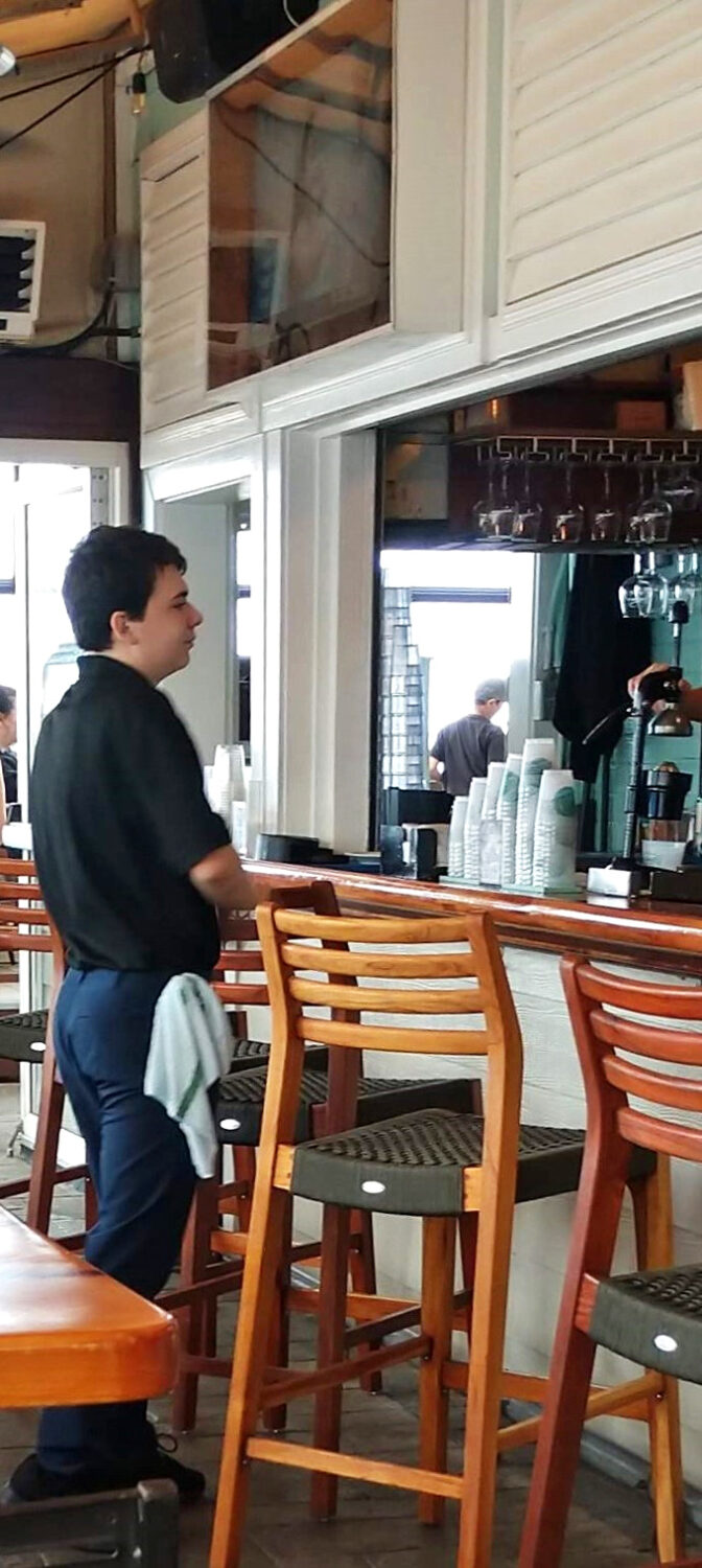 The staff navigates the bustling bar with practiced ease &ndash; these are the gatekeepers to your seafood paradise and masters of the legendary Orange Crush.