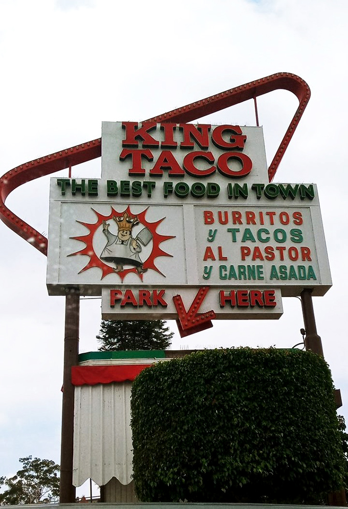 Not all heroes wear capes. Some hang on poles and guide hungry travelers to "THE BEST FOOD IN TOWN" with neon certainty.