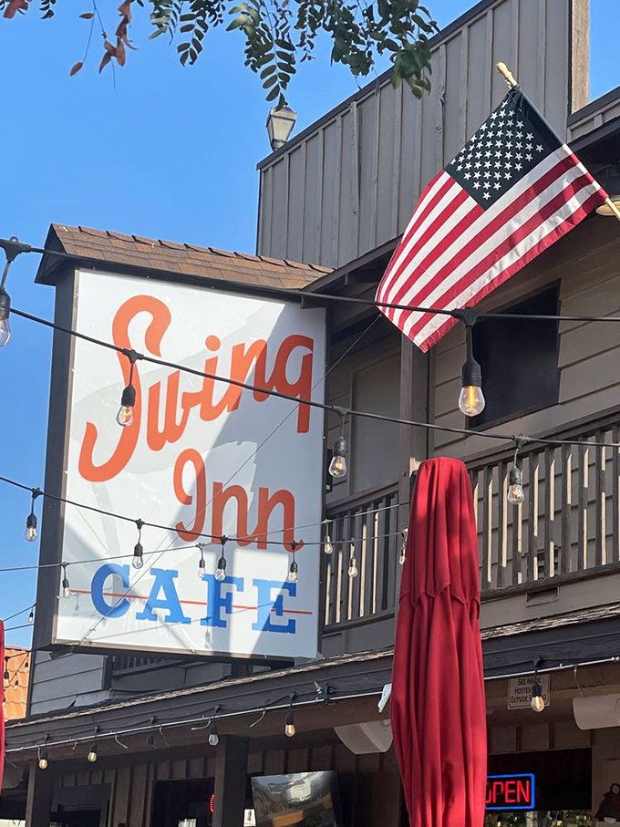 The Swing Inn sign stands proud against the California blue sky, an American flag fluttering beside it like the perfect patriotic garnish.