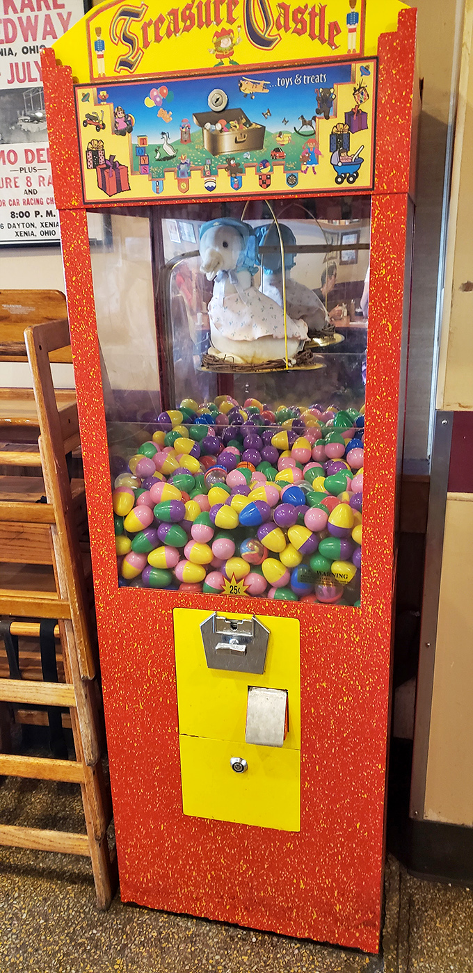 The toy machine by the door—where kids learn the valuable life lesson that happiness costs a quarter and usually gets stuck halfway up.