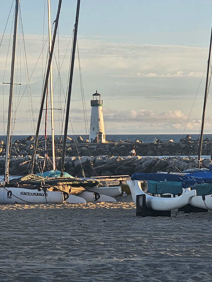 A sailor's welcome home framed by masts and rigging. The lighthouse keeps watch while boats rest easy, like a maritime version of a night light.