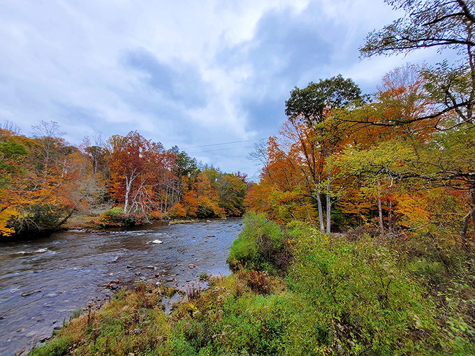 Peering over the side reveals the rocky foundation and crystal waters below. That perfect leaf-peeping reflection wasn't planned, but nature delivers.