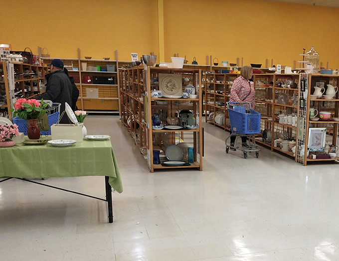Serious thrifters know the housewares section holds the real treasures. The concentration on these shoppers' faces says it all.