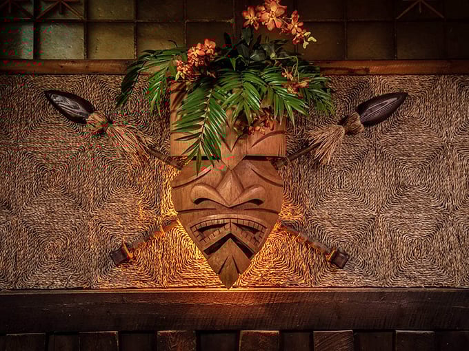 Hand-carved tiki wall art and tropical foliage create authentic Polynesian atmosphere that respects cultural traditions.