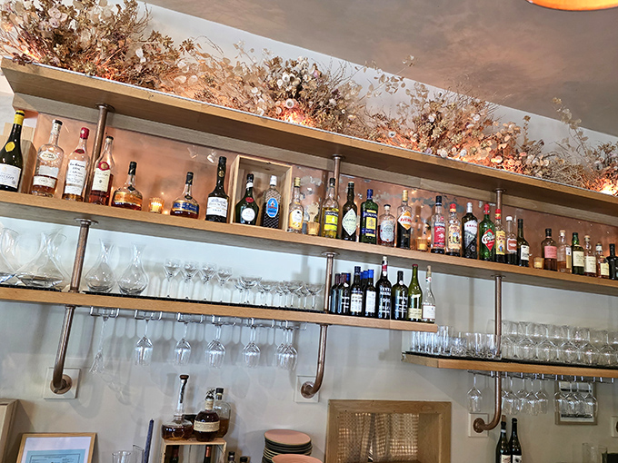 The bar shelves tell stories of carefully selected spirits. That dried floral arrangement above isn't just decoration&mdash;it's a hint at the seasonal philosophy below.