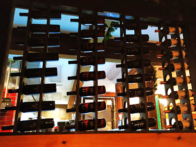 Wine bottles standing at attention like soldiers guarding flavor country. Each one waiting for its moment to complement the perfect cut of beef.