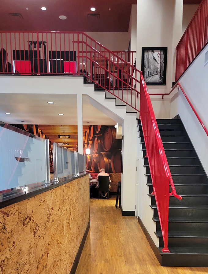 The dramatic red staircase leads upstairs like a runway for your dining experience—making even a trip to the restroom feel cinematic.