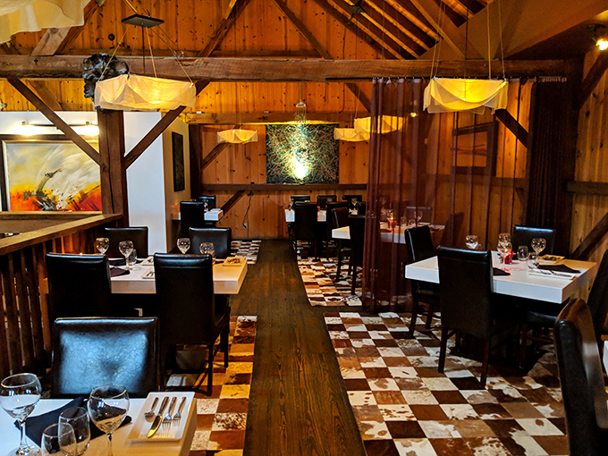 Dining room checkerboard floors play visual chess while wooden beams overhead remind you this was once a working barn. Now it works to satisfy appetites.