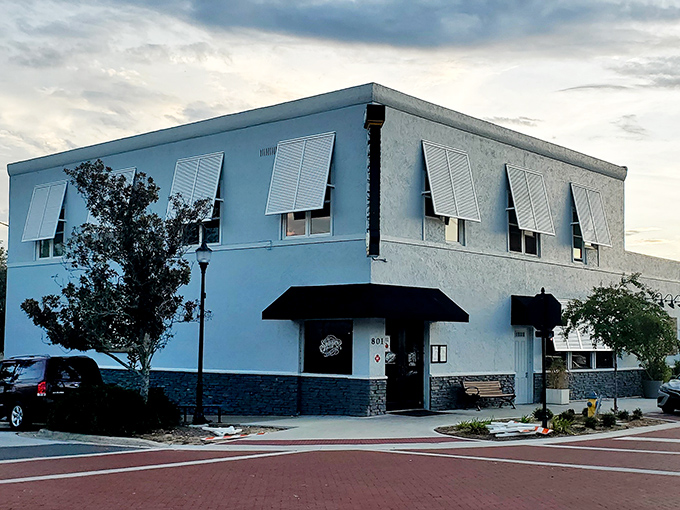 This minimalist white building with black awnings stands like a cool, collected local who knows all the best spots but isn't showy about it.