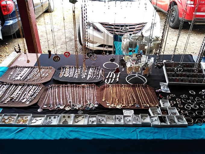 Necklaces cascade like metallic waterfalls across this jewelry display, where one person's "too much" is another's "just enough."