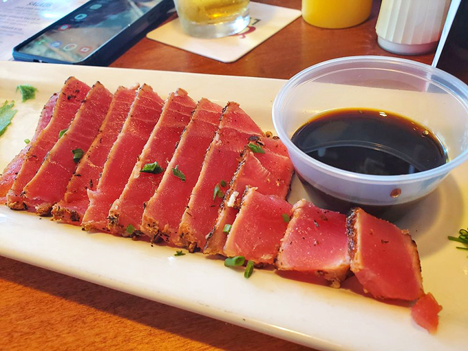 Ahi tuna sliced with the precision of a surgeon who really, really loves fish. That soy sauce is just waiting to complete the masterpiece.