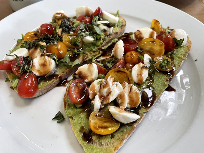 Avocado toast elevated to an art form. This colorful masterpiece with heirloom tomatoes and fresh mozzarella is California on a plate.