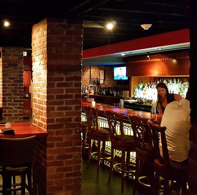 The warm glow of this bar area invites you to pull up a stool and stay awhile. Brick archways frame the space like a portal to a more civilized era.