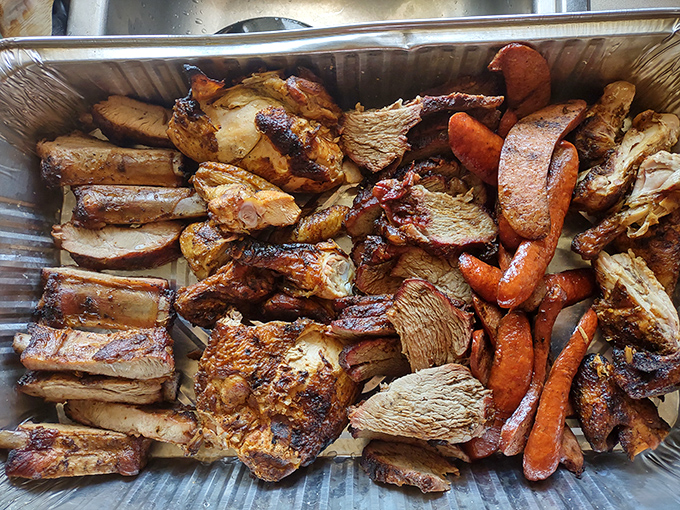 A barbecue platter that's basically a family reunion of meats &ndash; ribs, chicken, and sausage sharing space with carrots that snuck into the smoker.