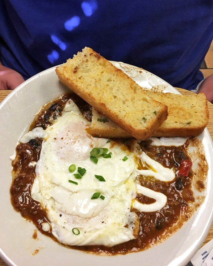 A bowl of black bean chili topped with eggs and toast soldiers. Breakfast and dinner had a delicious baby, and this is it.