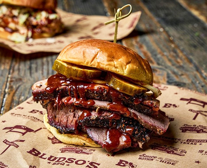 This brisket sandwich isn't just lunch&mdash;it's architecture. Layers of smoke-kissed beef with sauce dripping down the sides, held together by a bun that knows its role.